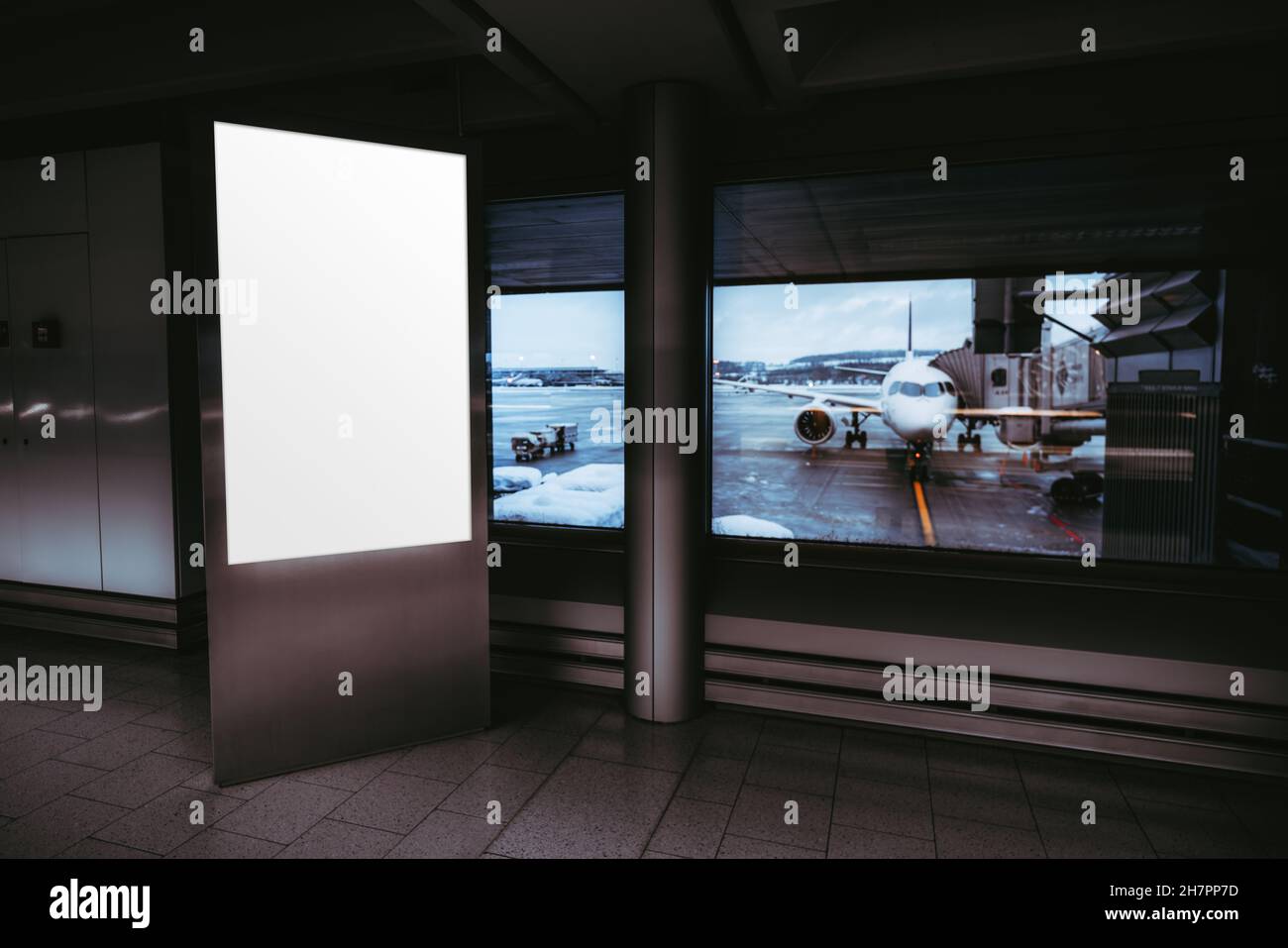 A blank poster mockup in the gate area of an airport with an airplane ...