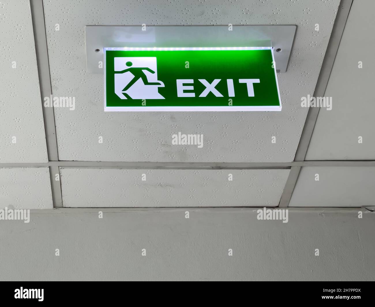 The green fire exit symbol on the ceiling shows escape routes outside ...