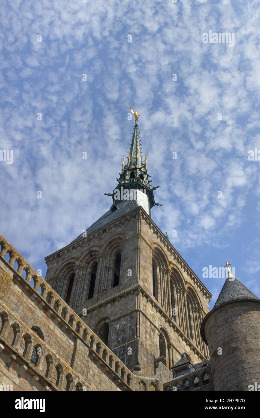 spire of the abbey of Mont Saint Michel, Normandy, France. Sky is blue ...