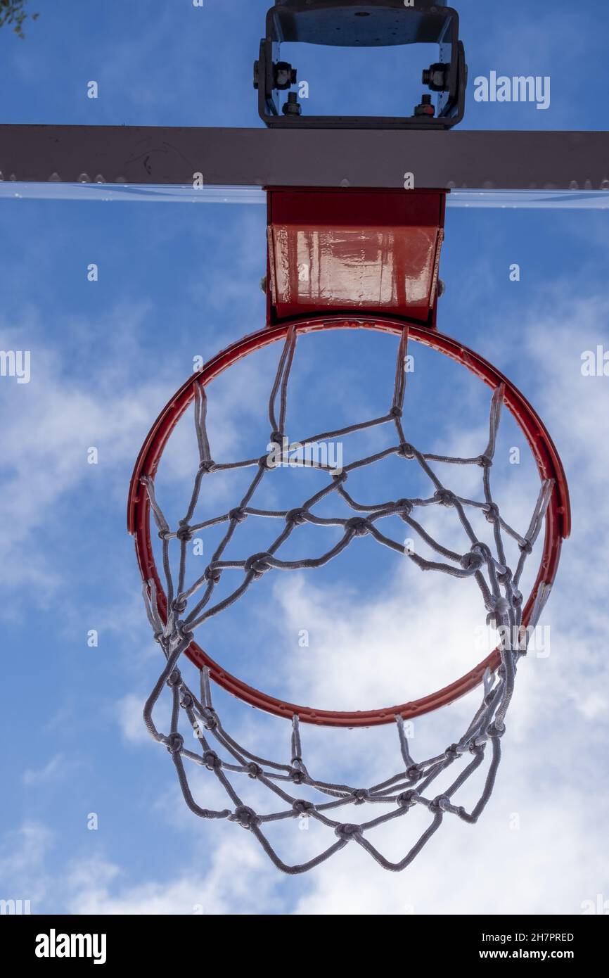 Vertical low angle shot of a basketball ring against cloudy sky Stock ...