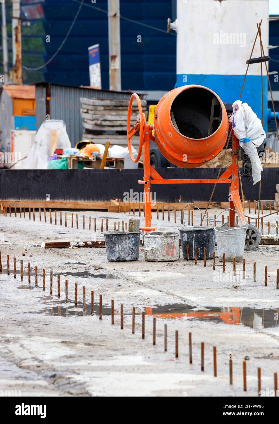 A large construction orange mortar mixer stands against the backdrop of ...