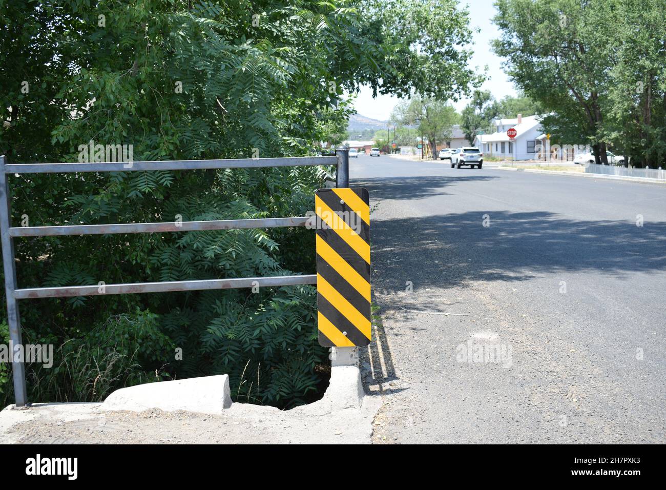 A black and yellow striped sign warns of road abutment Stock Photo - Alamy