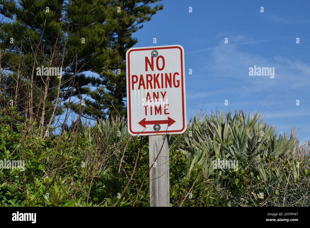 A no parking sign attached to a wooden post Stock Photo - Alamy