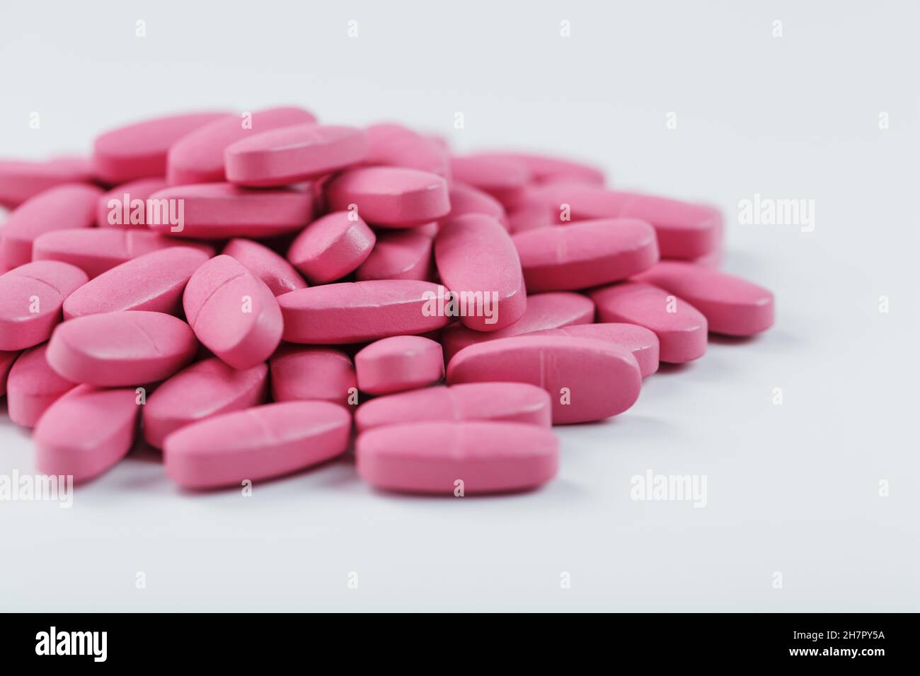 Pink vitamin pills for women on a white background. Multivitamins for ...