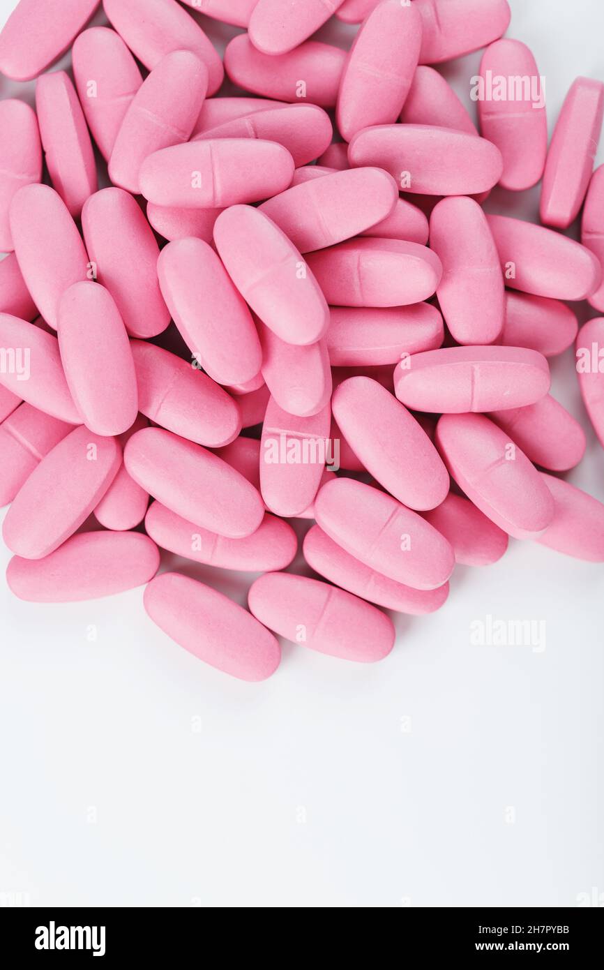 Pink vitamin pills for women on a white background. Multivitamins for ...