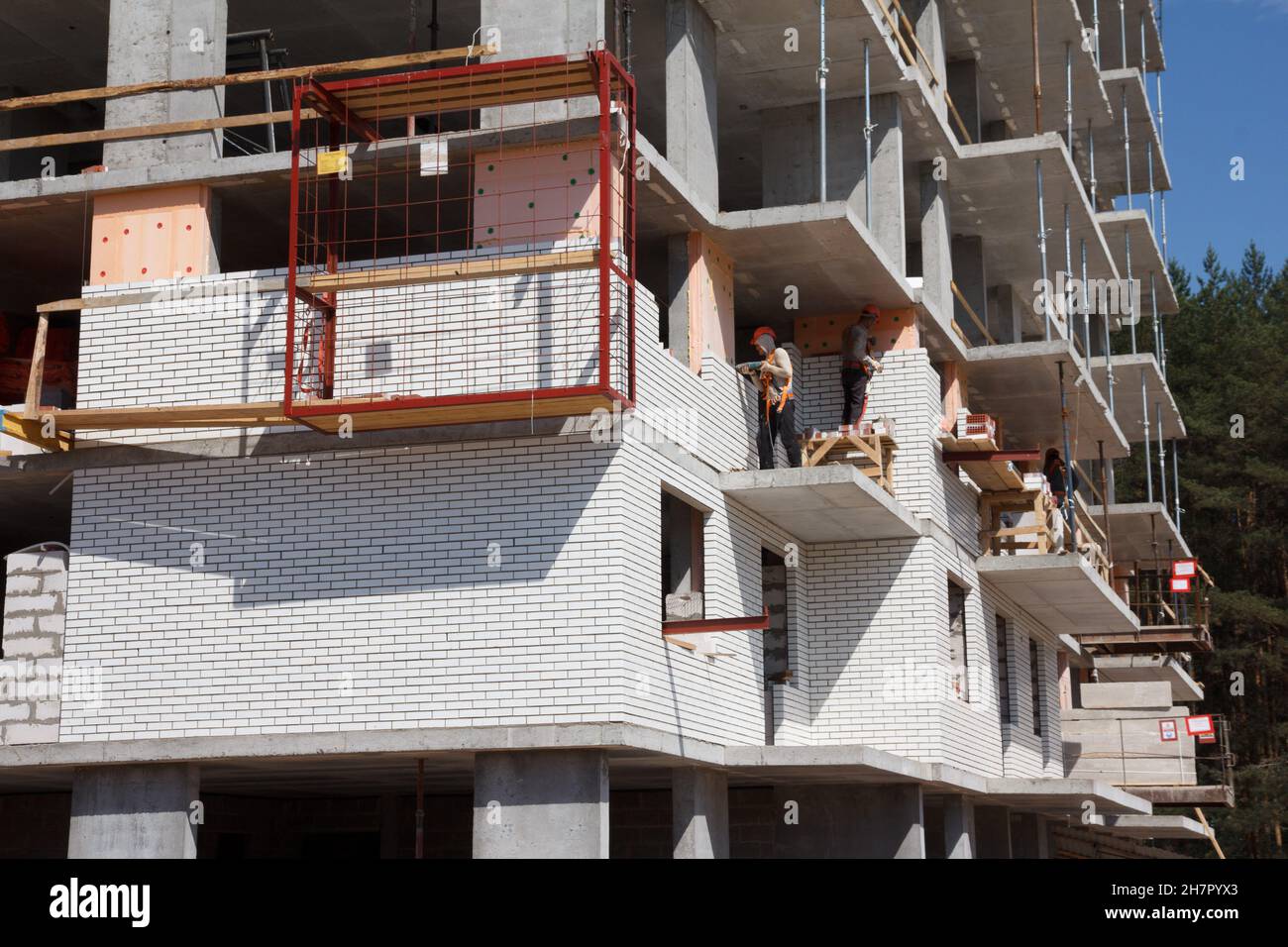 Finishing the facade of an apartment building under construction ...