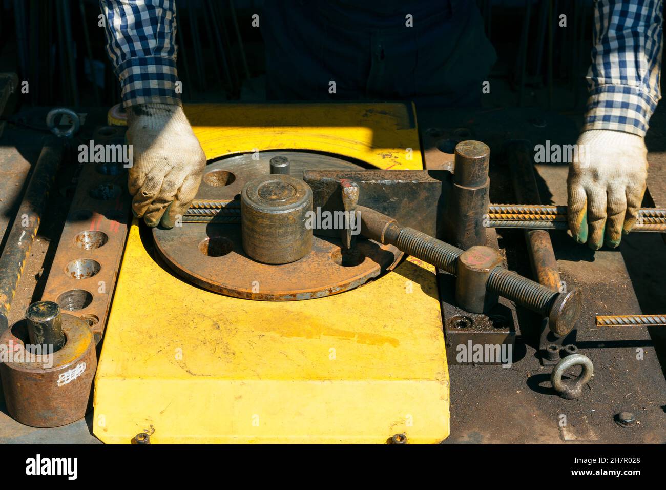 Hands of a worker at work at the armature bending machine. Rebars with ...