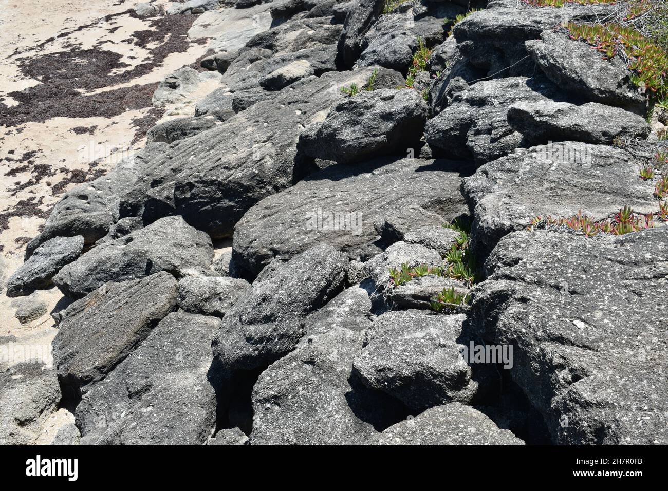 Flat boulders stacked as a barrier seawall Stock Photo - Alamy