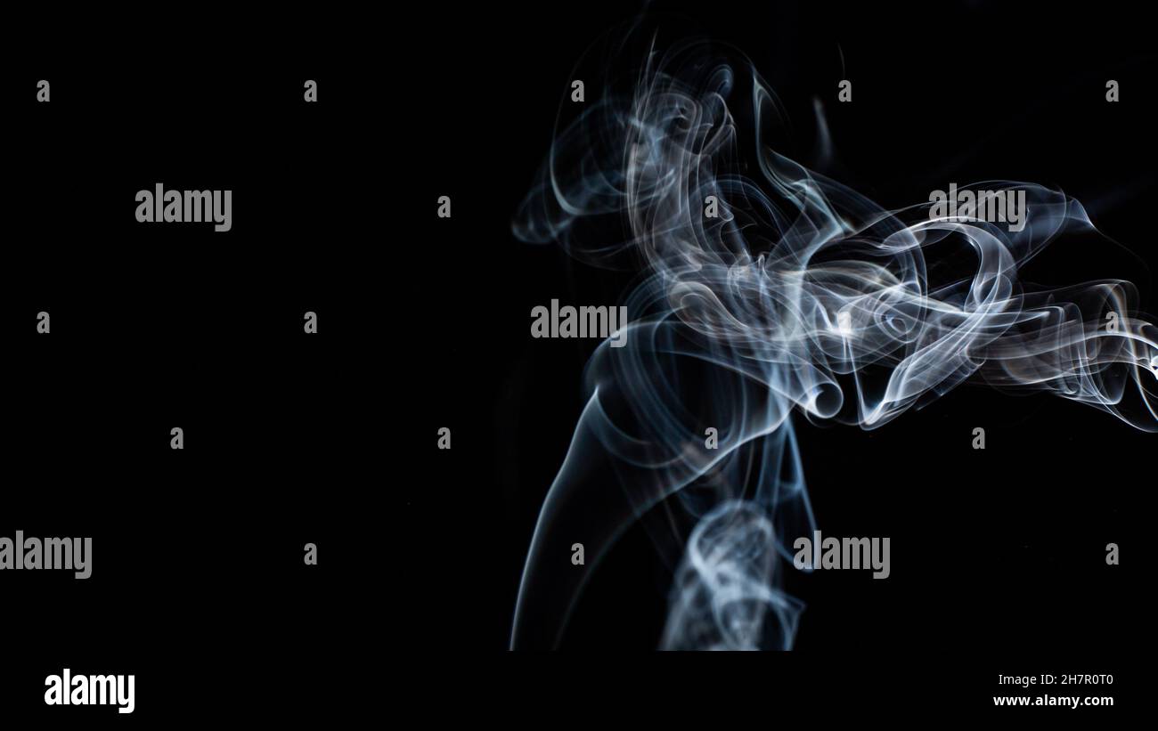 Smoke curves on a dark black background Stock Photo - Alamy