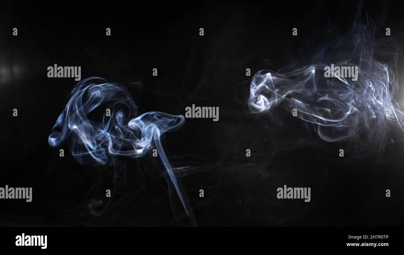 Smoke curves on a dark black background Stock Photo - Alamy