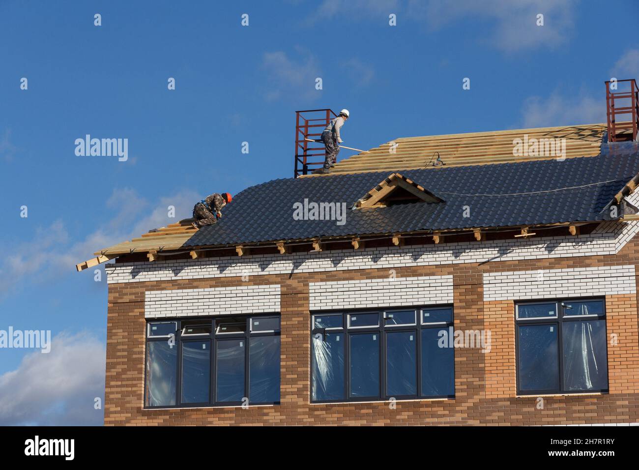 Roofing work on a building under construction. Laying a new roof ...