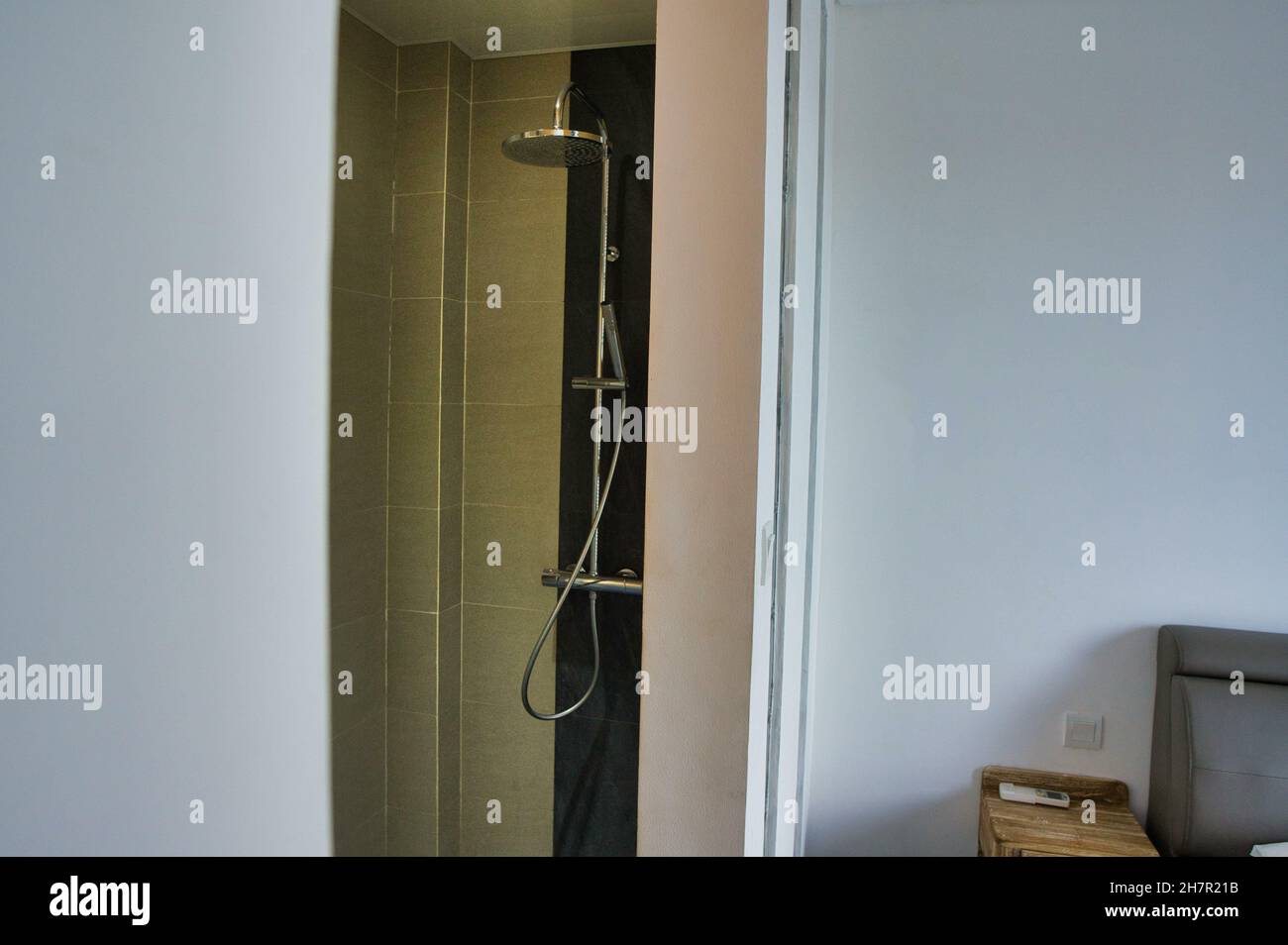 Shower booth indoors with a plain white wall behind it Stock Photo - Alamy