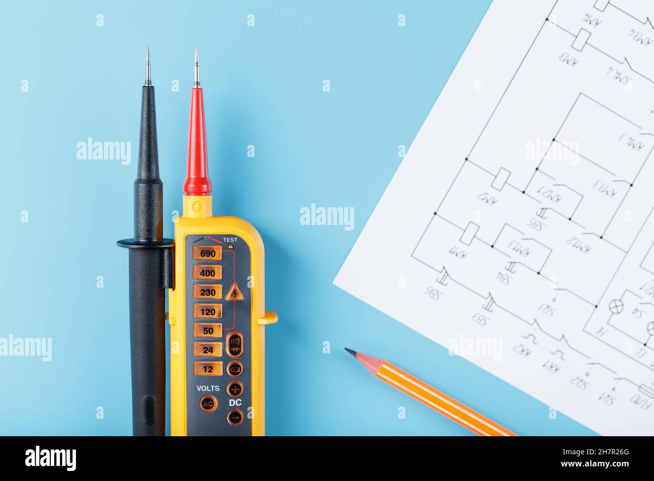 Two-pole voltage indicator with electrical drawings on a blue ...