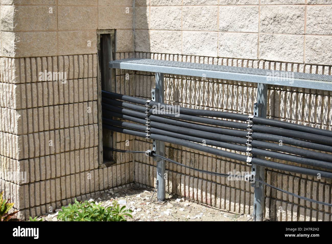 Large cables feed into a rock wall Stock Photo - Alamy