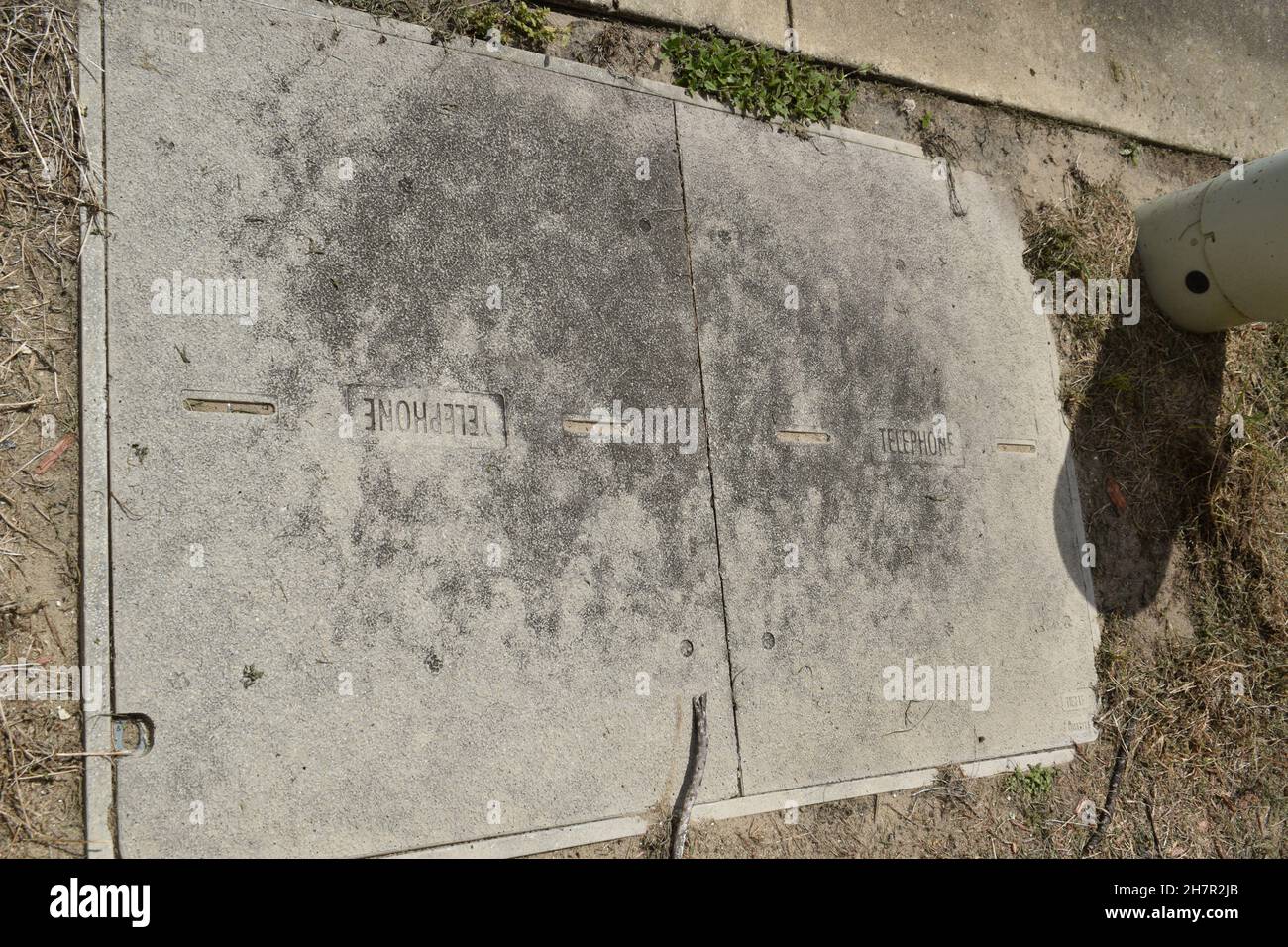 A concrete cover over underground telephone components Stock Photo - Alamy