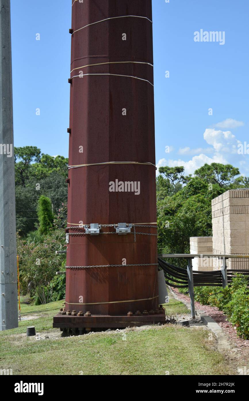 The base of a massive rust colored tower with large data cables ...