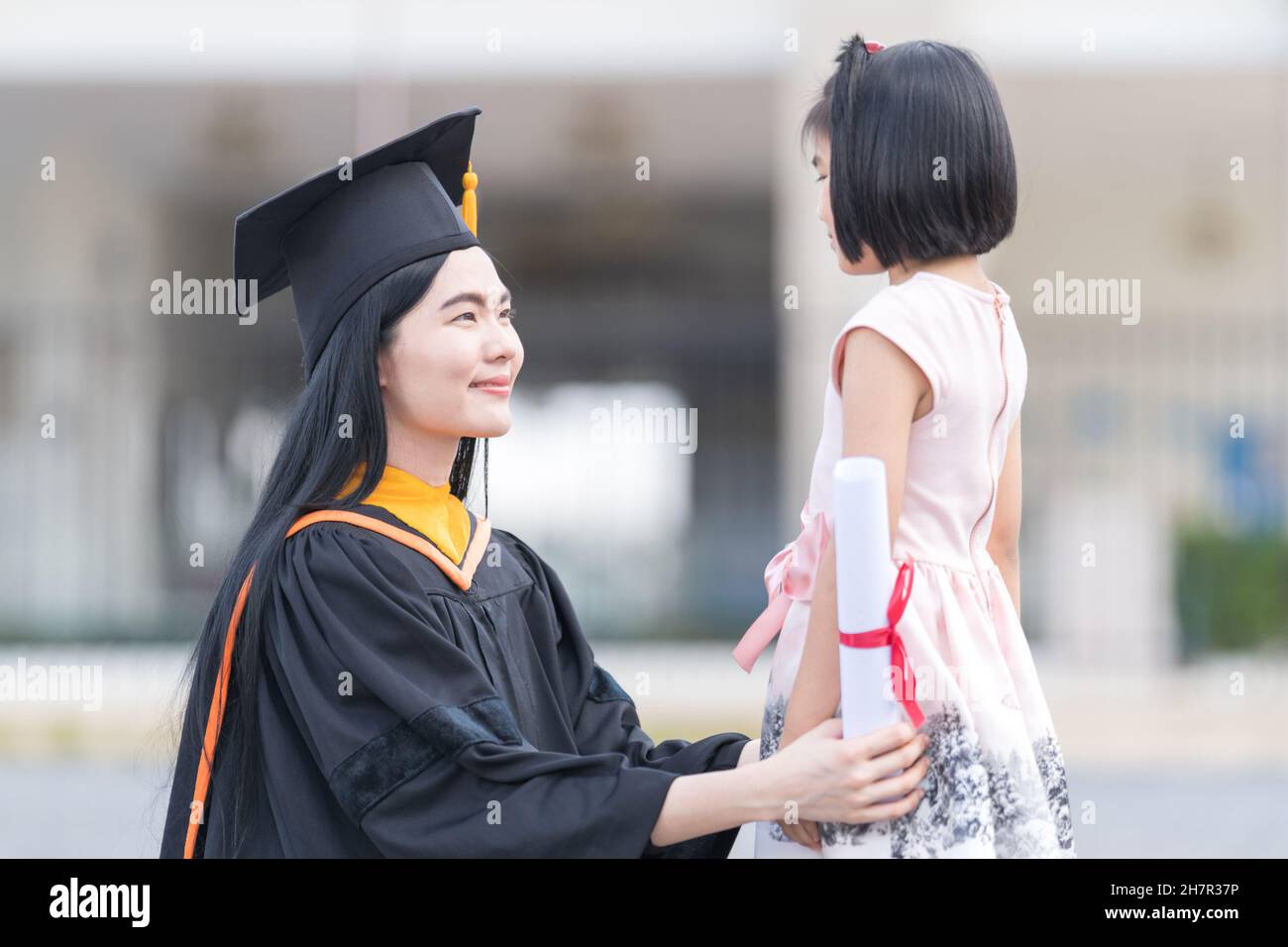 Southeast Asian woman graduate with a little girl on her graduation day ...