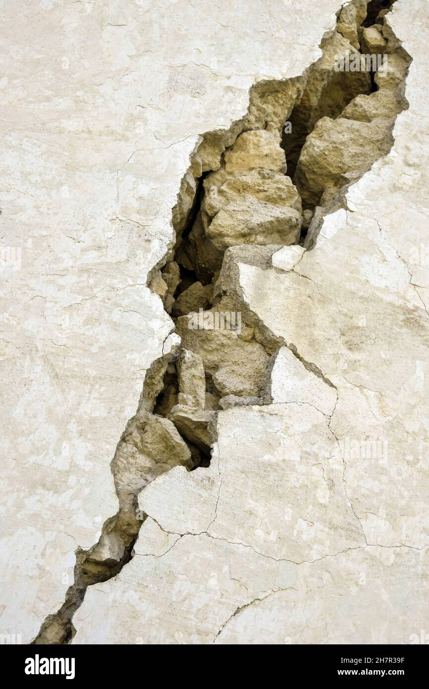 Big diagonal crack in wild shell stone masonry covered with plaster ...