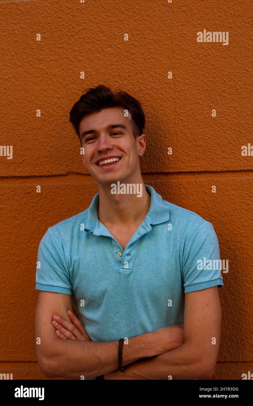 Handsome smiling Spanish male leaning on a wall Stock Photo - Alamy