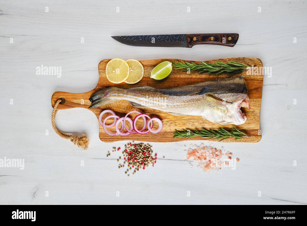 Fresh gutted and headless cod carcass on wooden cutting board Stock ...