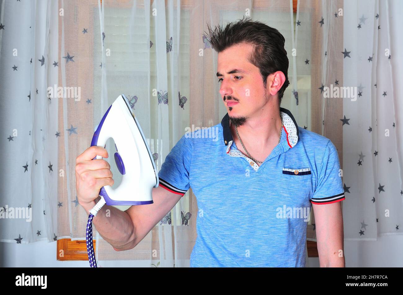 Checking if steam is coming out of the iron Stock Photo - Alamy