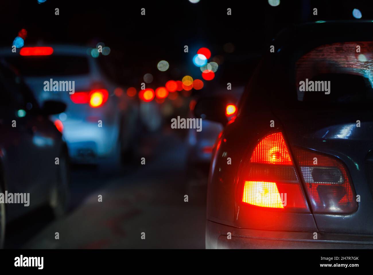 close-up view of car tail light and right turn signal at night traffic ...
