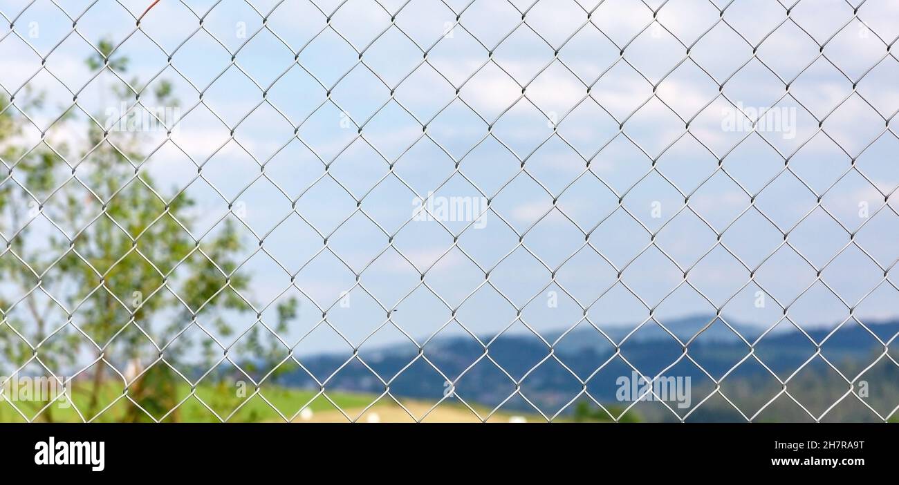 Beautiful plains landscape behind a metal net fence, confinement ...
