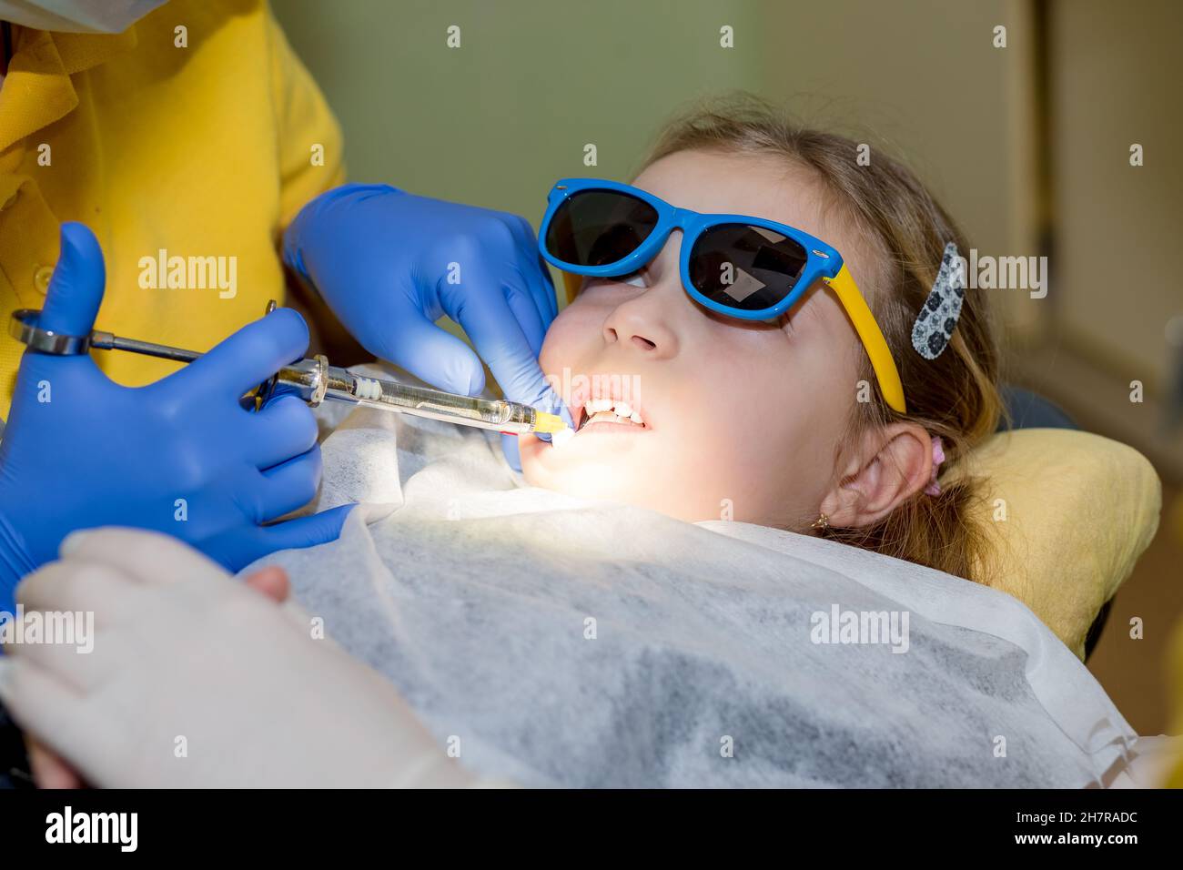 partial view of dentist giving injection on anesthesia to patient in ...