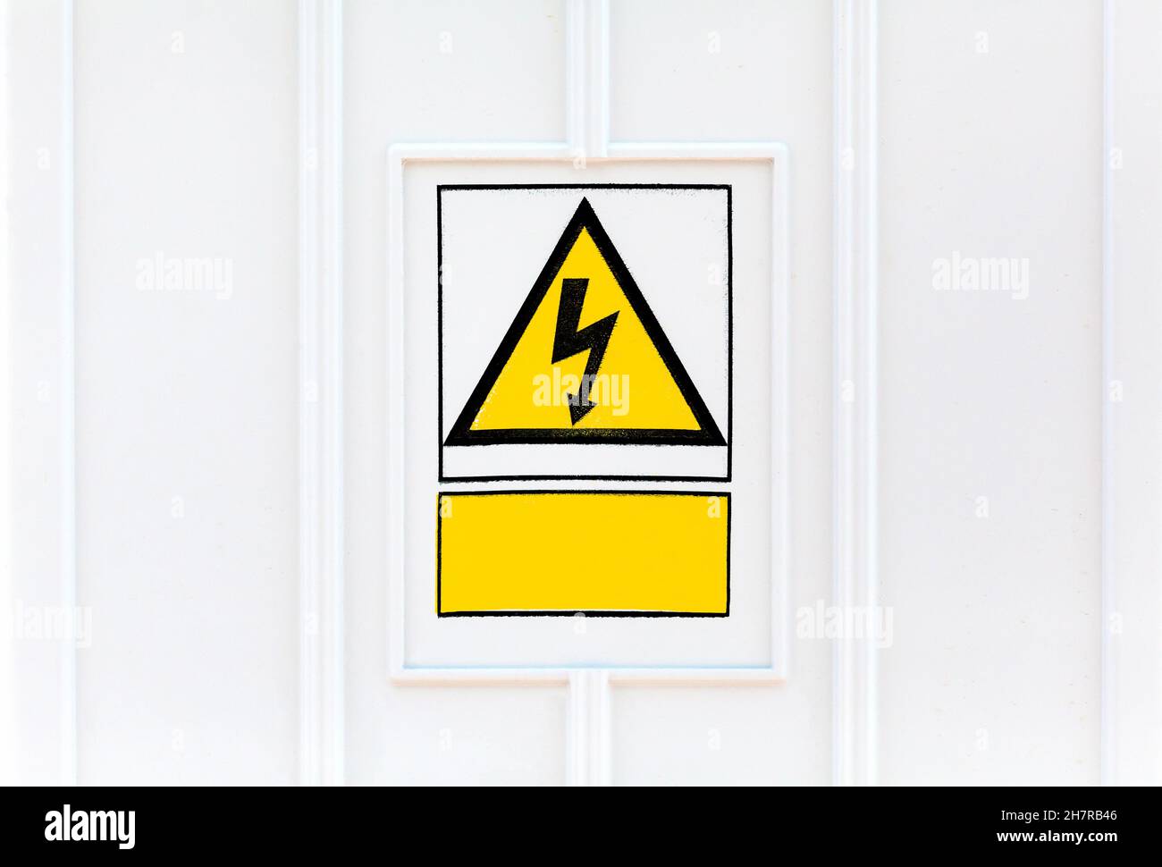 High voltage yellow triangle warning plate with an empty rectangle text ...