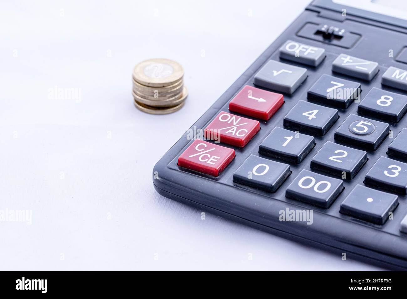 Coins and calculator on an isolated white background Stock Photo - Alamy
