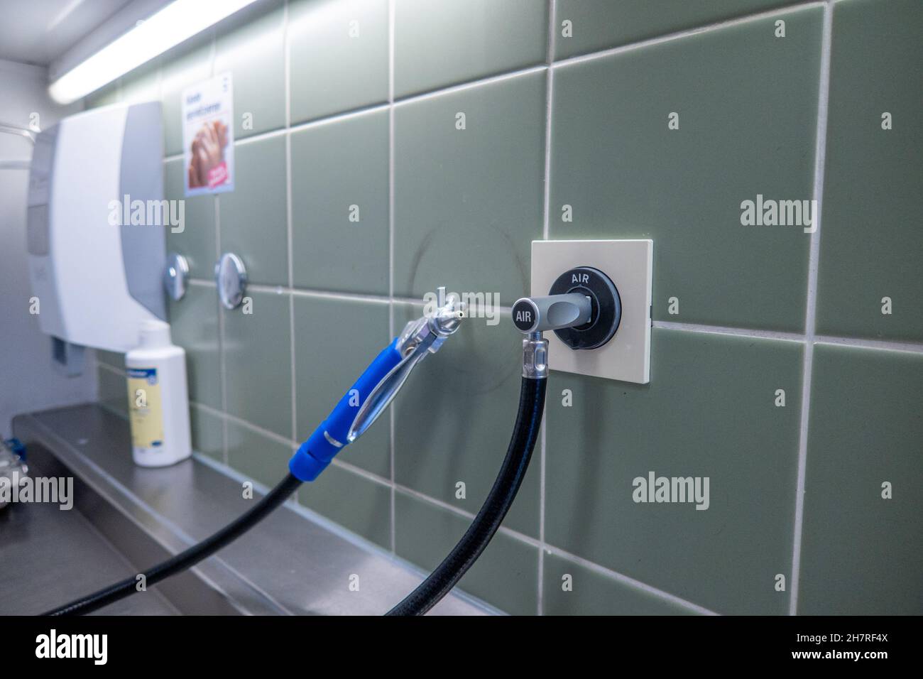 a compressed air gun is connected to a wall connection in a hospital ...