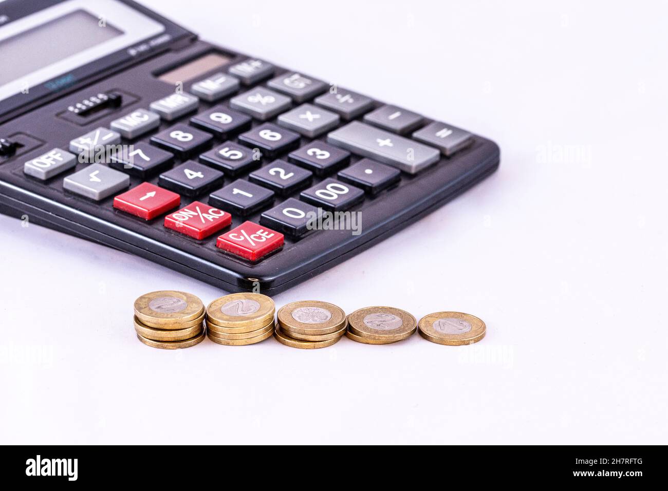 Coins and calculator on an isolated white background Stock Photo - Alamy