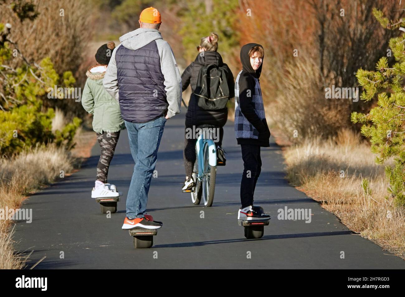 A family riding hoverboards navigates a walking and bike path in the ...