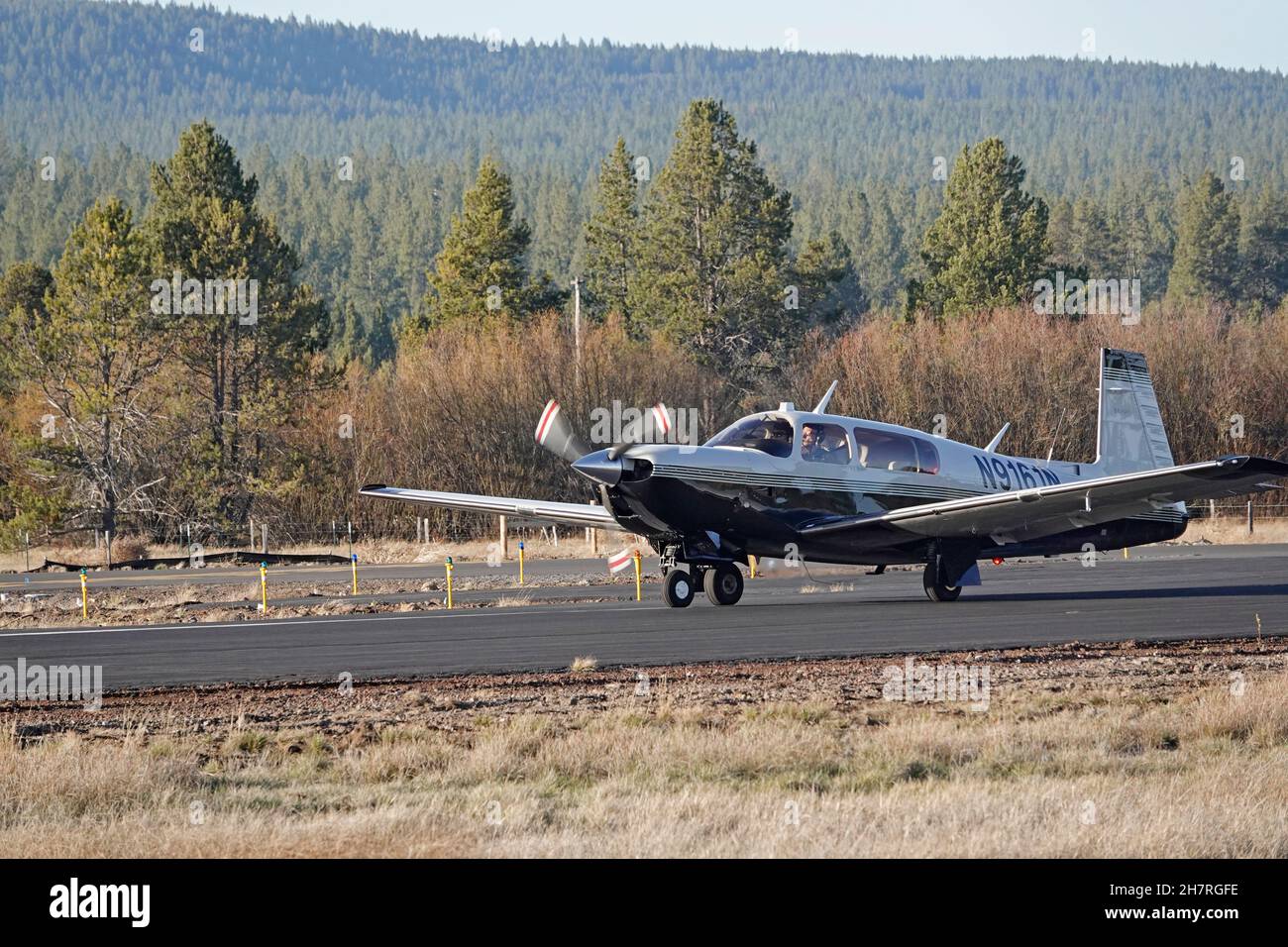 A Mooney M20M single engine aircraft, taking off at a small country ...