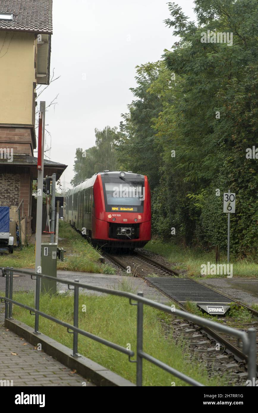 Red train on the railway near the station Stock Photo - Alamy
