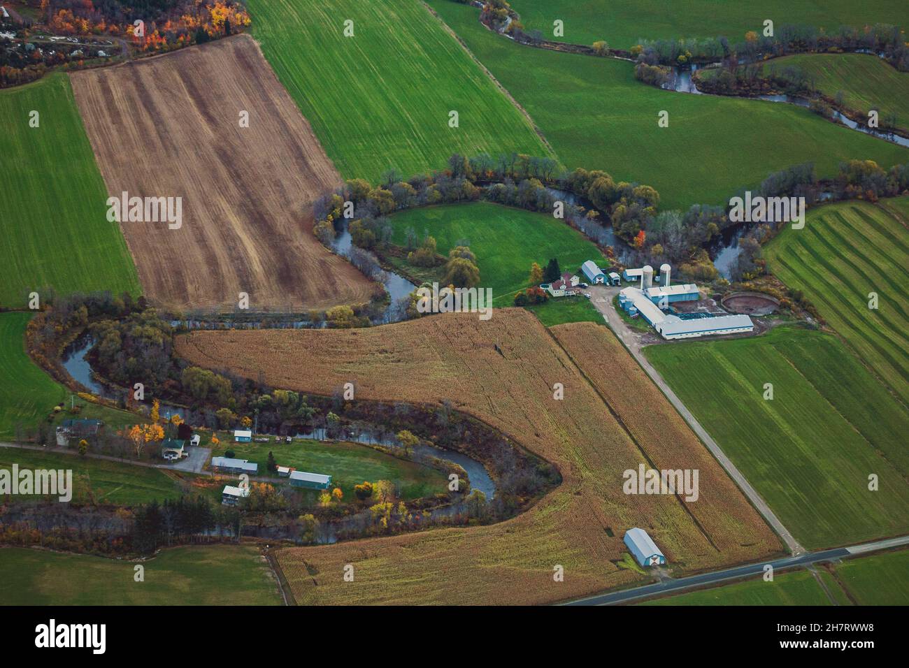 Landscape of farm field crops and trees in the daylight in Kamouraska ...