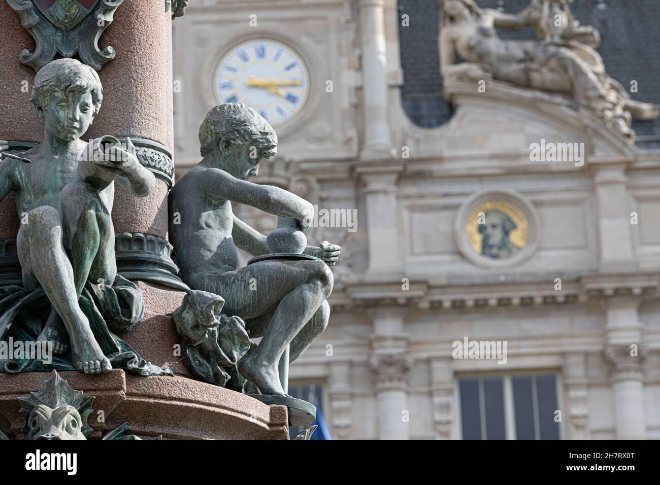 Column with sculptures of boys and a fountain Stock Photo - Alamy