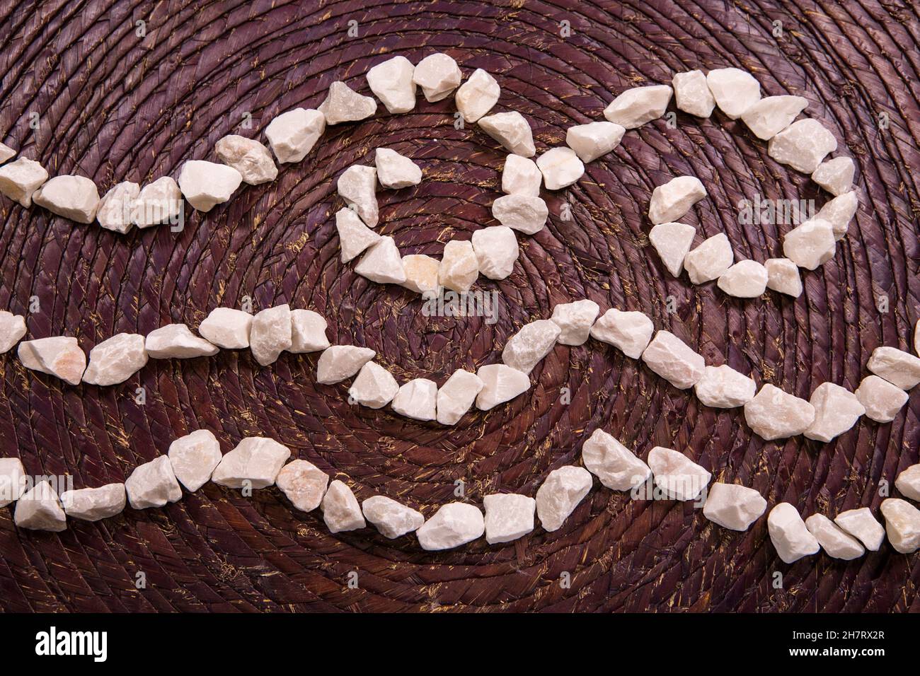 Wind Water Symbol written with white stones over a rustic purple ...