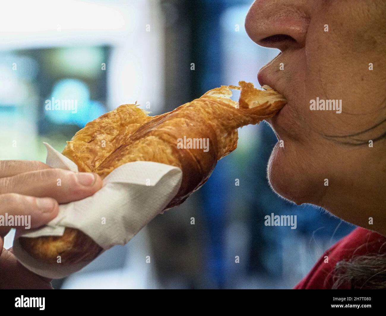 Old Hispanic woman eating a croissant in a cafe Stock Photo - Alamy
