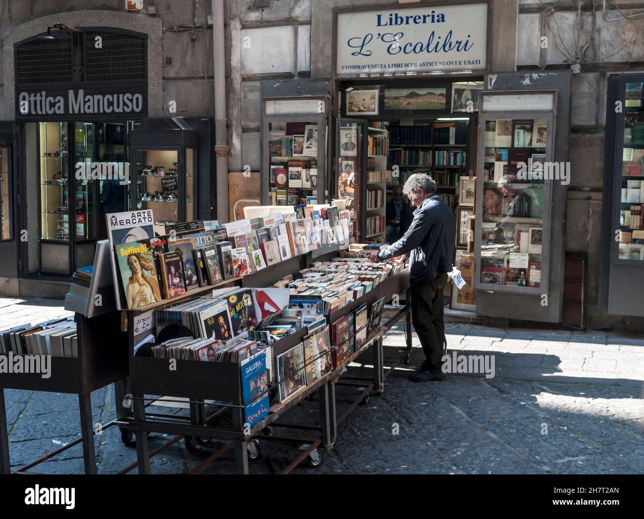 A man checking out old books, LPs, and pamphlets on display in the ...