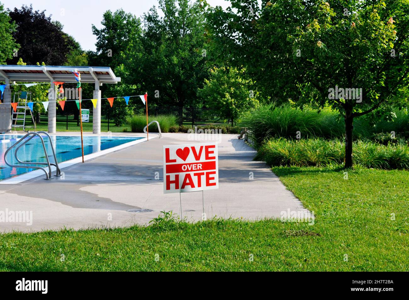 Love over hate sign posted at a public swimming pool in a lovely park ...