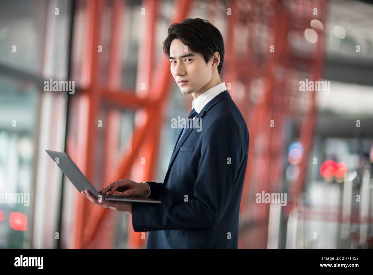 Young business man using a laptop in an airport lounge Stock Photo - Alamy