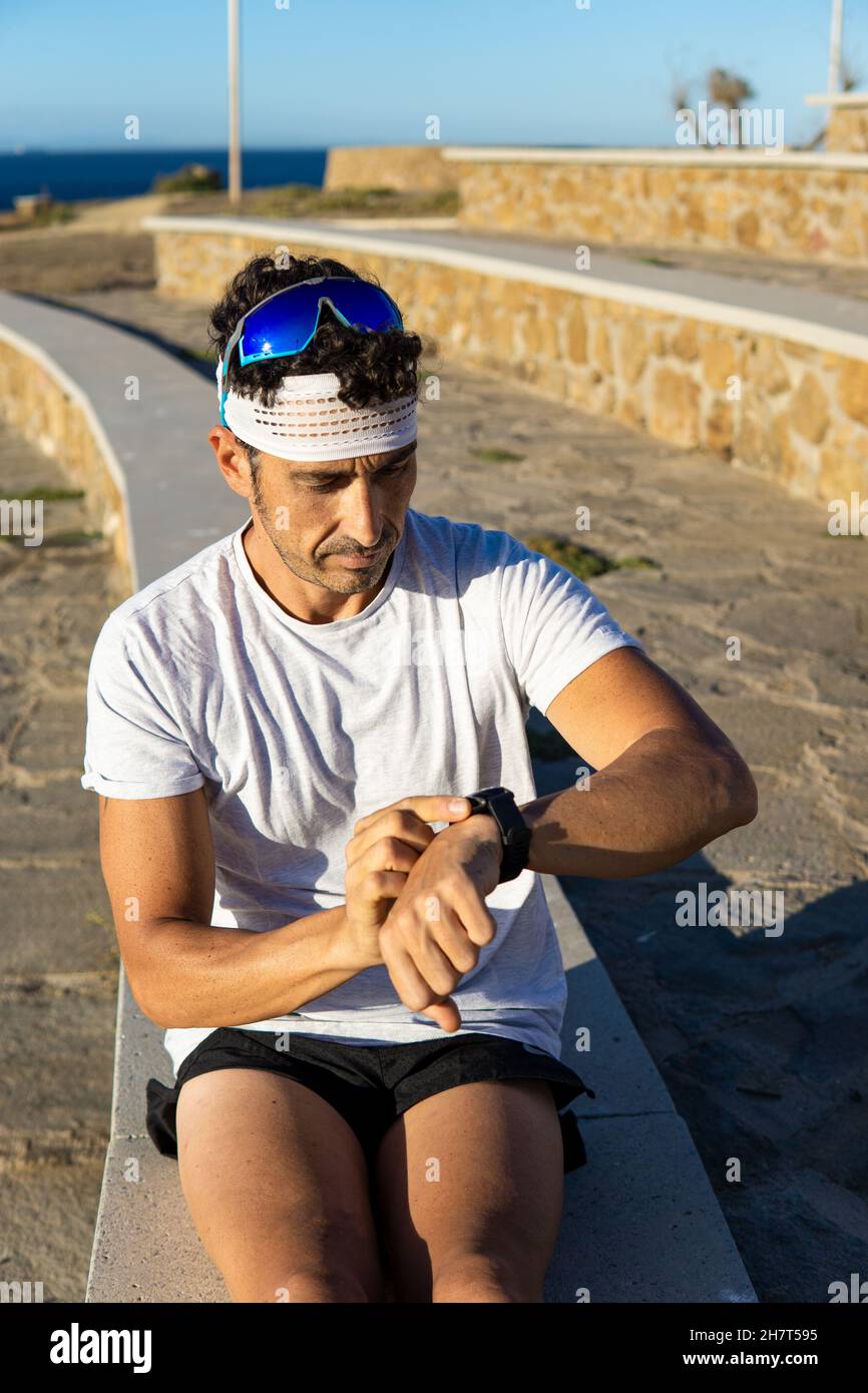 Young caucasian man checking pulse on a smartwatch in an outdoor Stock ...
