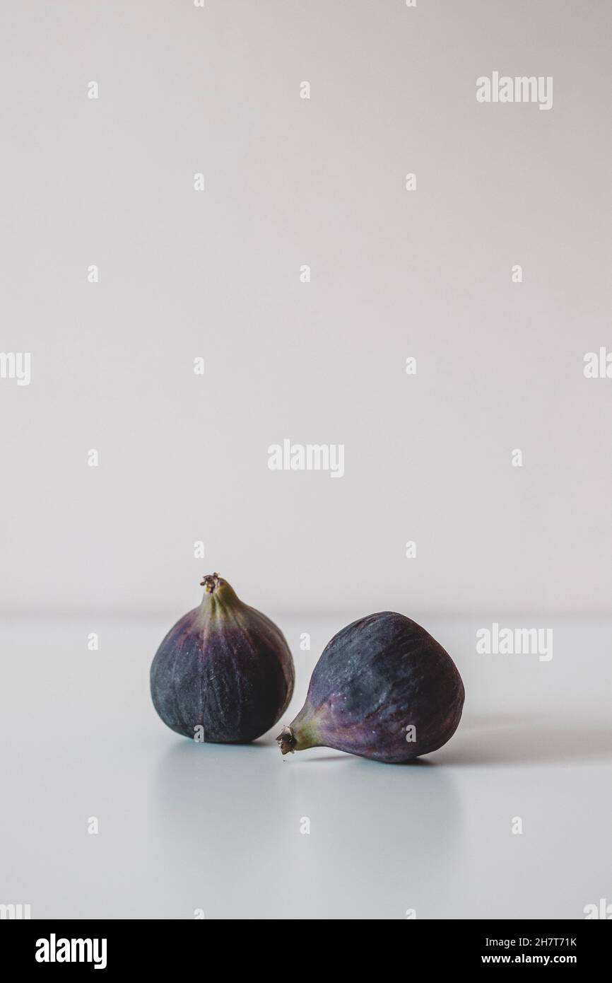 Two fresh fruit harvest of whole ripe figs on the table on grey ...