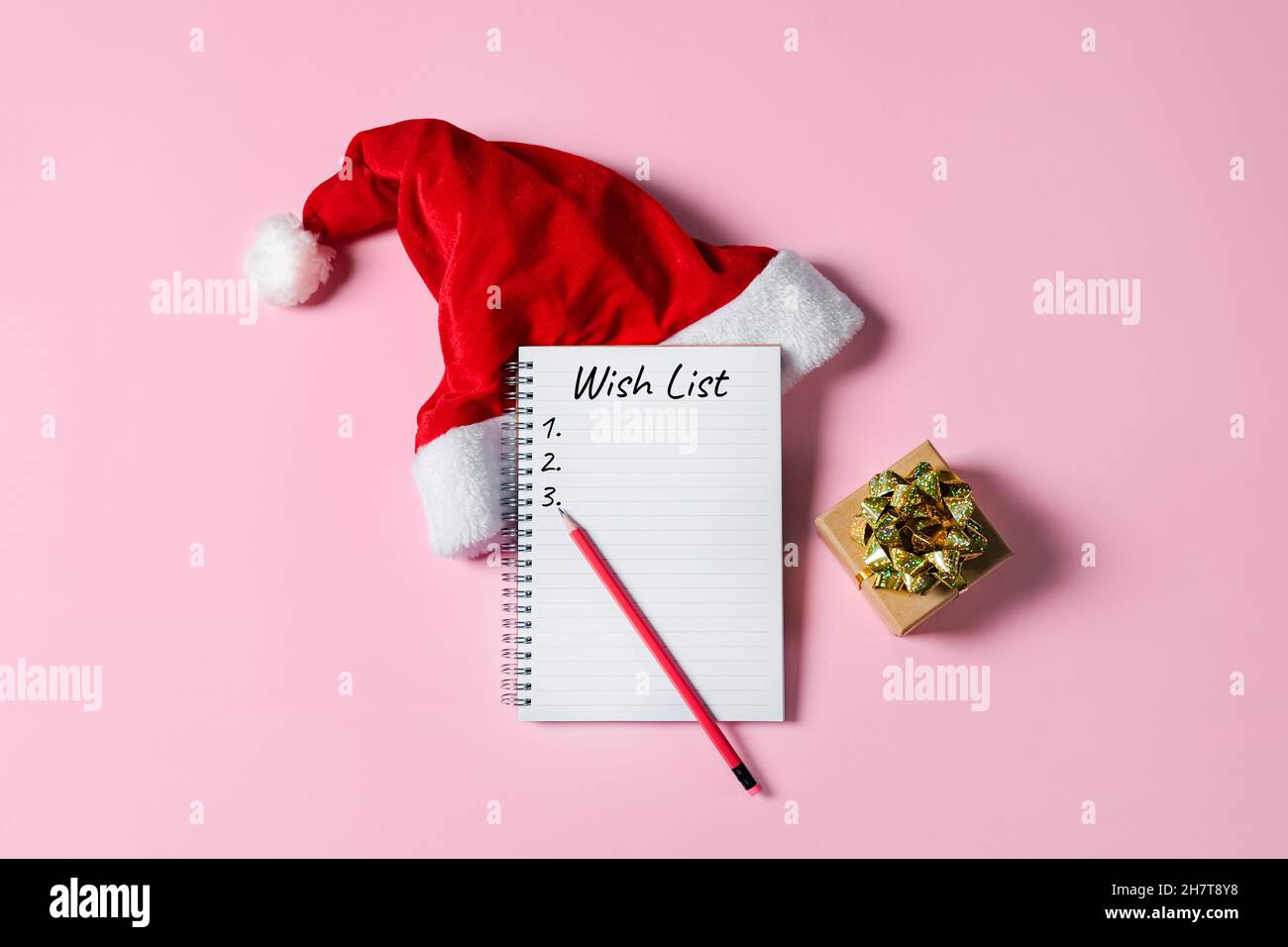 New Year or Christmas wish list concept. Notepad, Santa Claus hat and ...