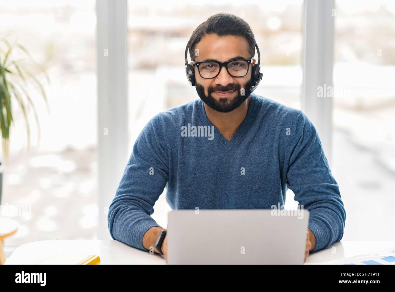Indian male salesman in a headset is holding the call, ethnic customer ...