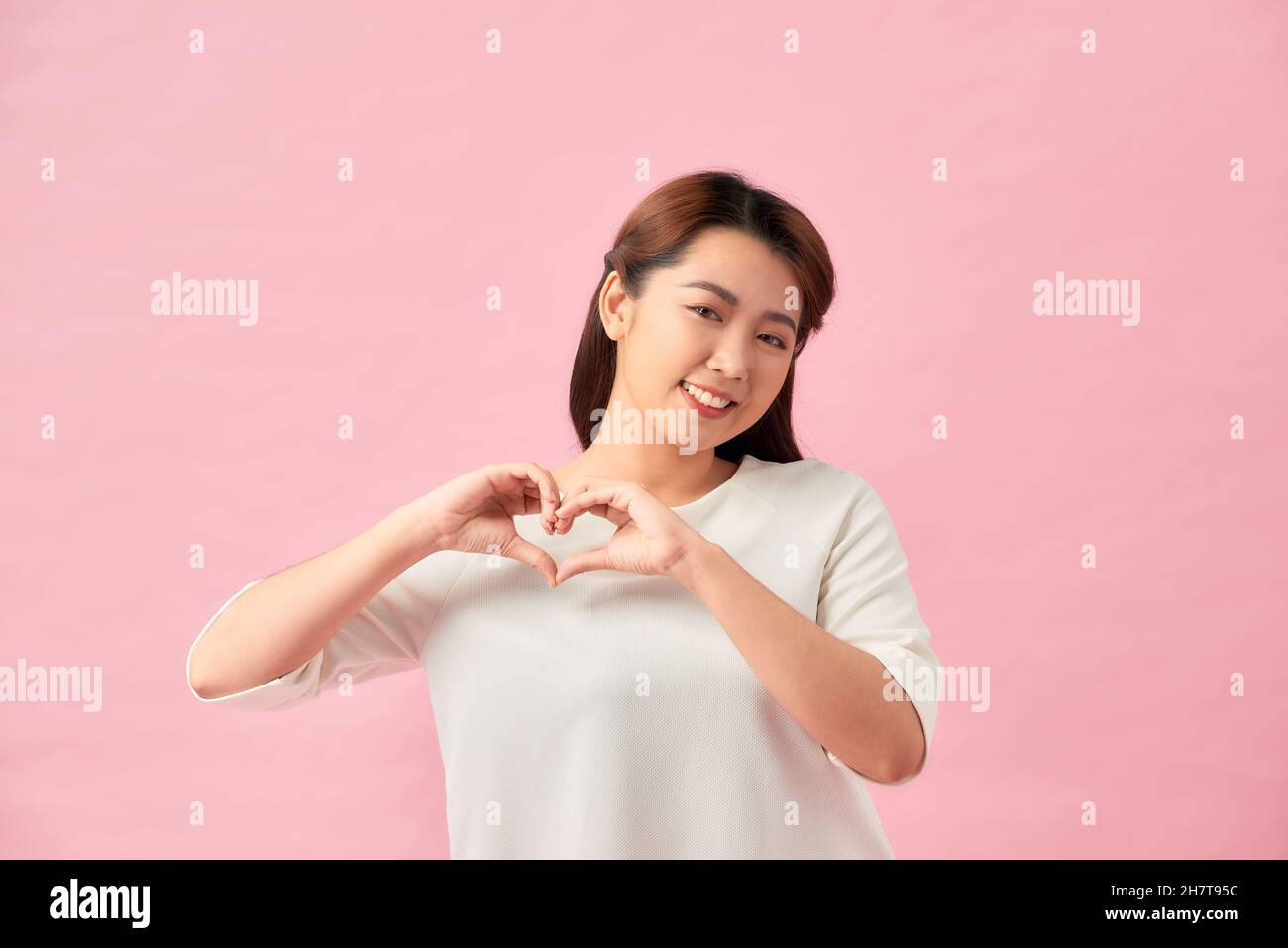 Smiling young girl showing heart with two hands, love sign Stock Photo ...