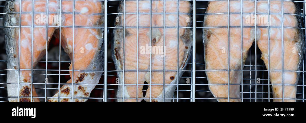 Several cooked slices of fish on a barbecue grill Stock Photo - Alamy