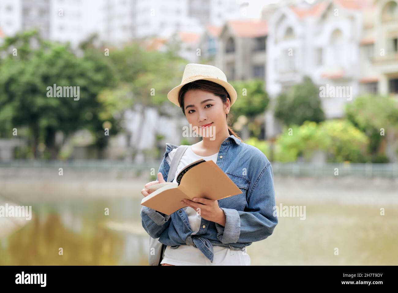 Tourist with travel guide book. Young woman traveler smiling happy ...
