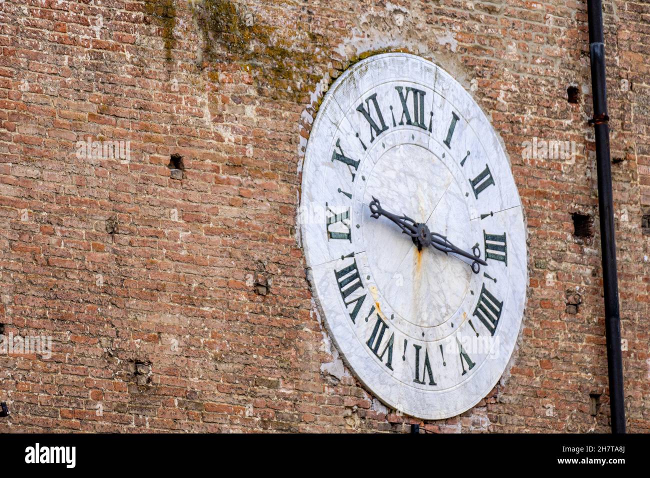 Big, round clock at a brick wall of a building Stock Photo - Alamy